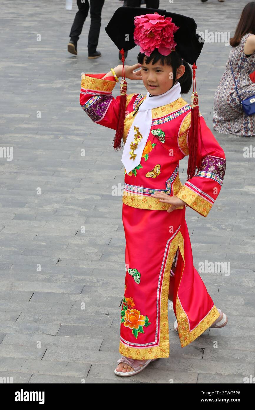 Young girl in red traditional chinese dress as part of period costume ...