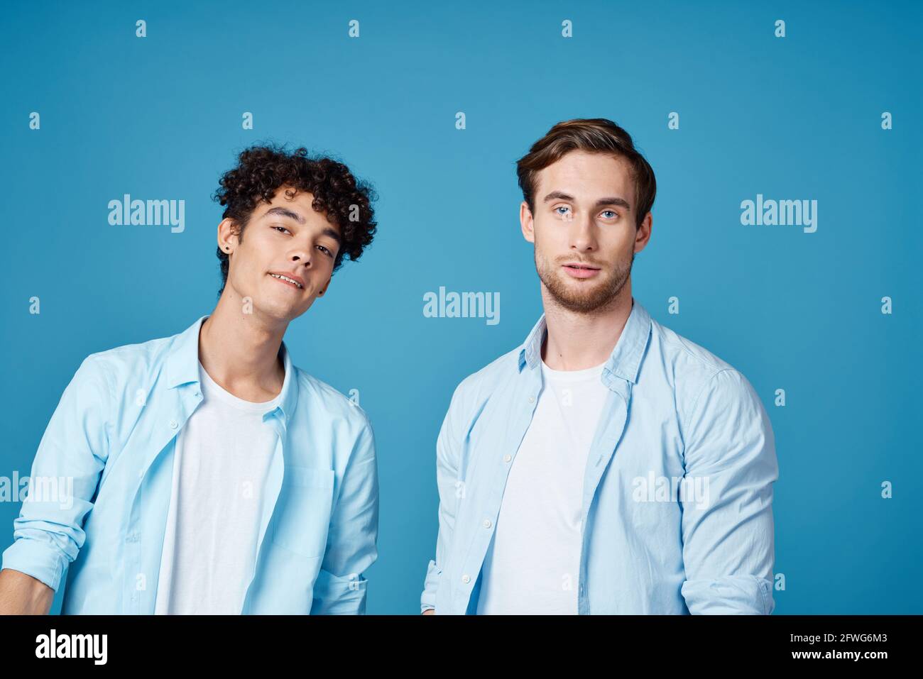 two friends in identical shirts and a t-shirt gesturing with their ...