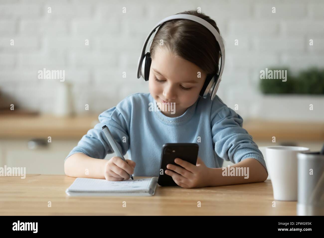 Little girl child study online using cellphone Stock Photo - Alamy