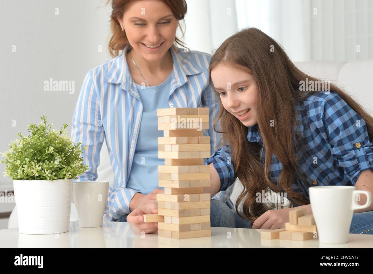 Happy girl and mother playing with blocks at home Stock Photo - Alamy