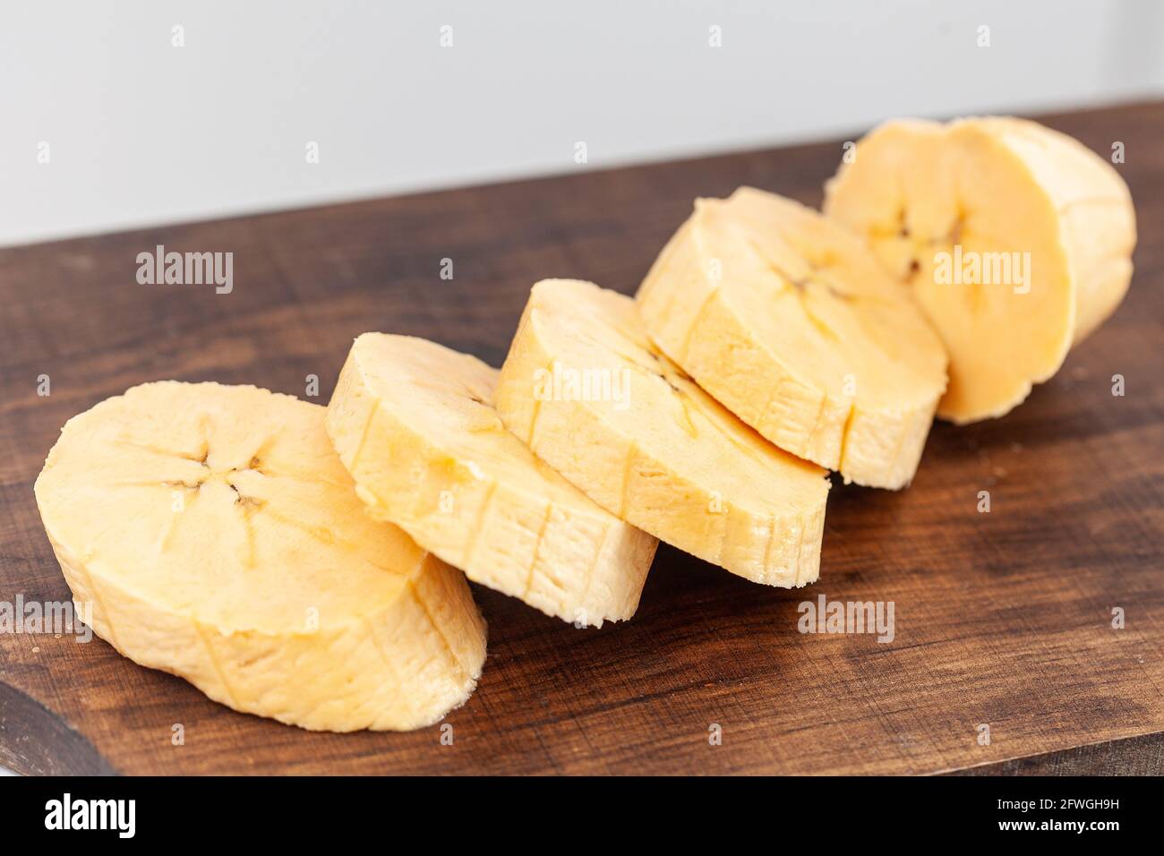 Closeup ripe plantain pieces over a wooden cutting board Stock Photo ...