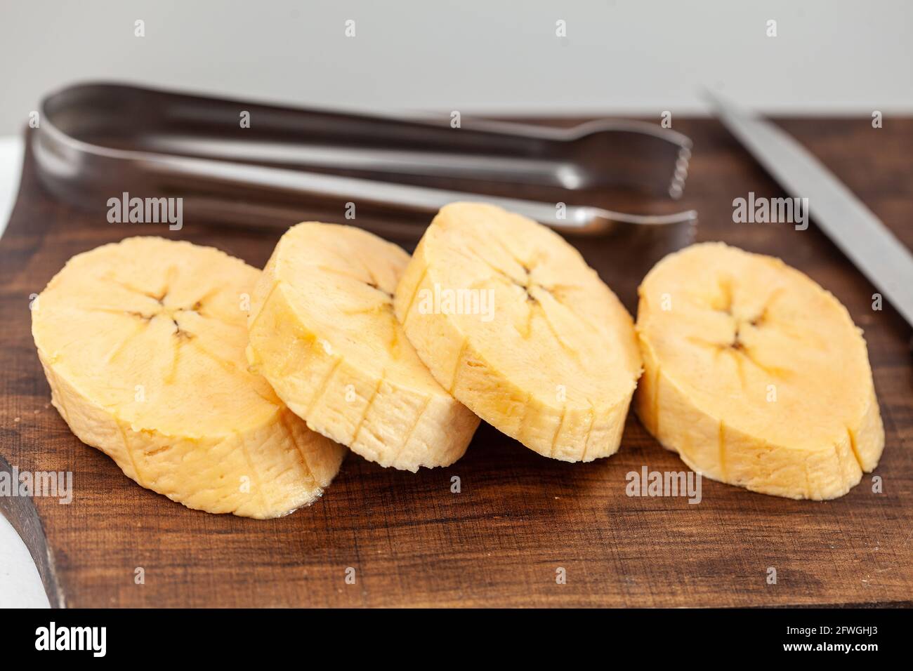 Closeup ripe plantain pieces over a wooden cutting board Stock Photo ...