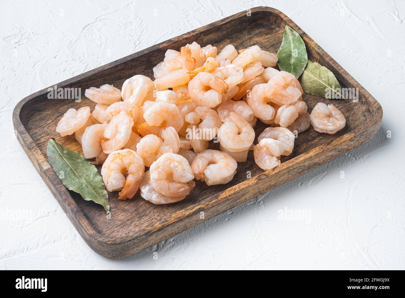 Boiled peeled shrimp prawns cooked set, on wooden tray, on white stone ...