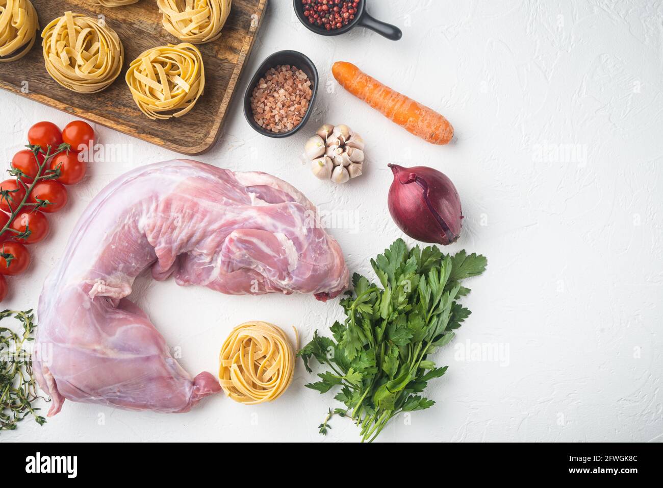 Raw rabbit meat with fresh vegetables ready for cooking set, on white ...