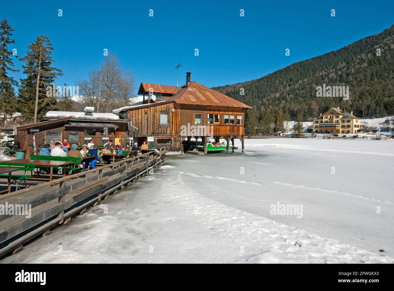 Dobbiaco lake in winter with bar-restaurant on stilts and historic ...
