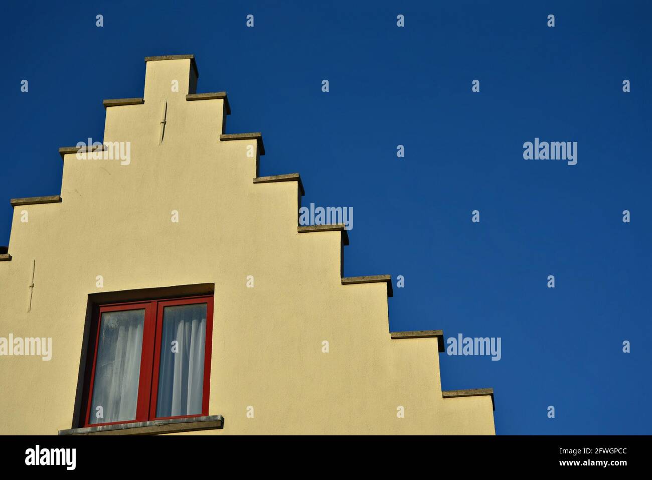 Gothic Revival house facade with a red window and a pointed rooftop in ...