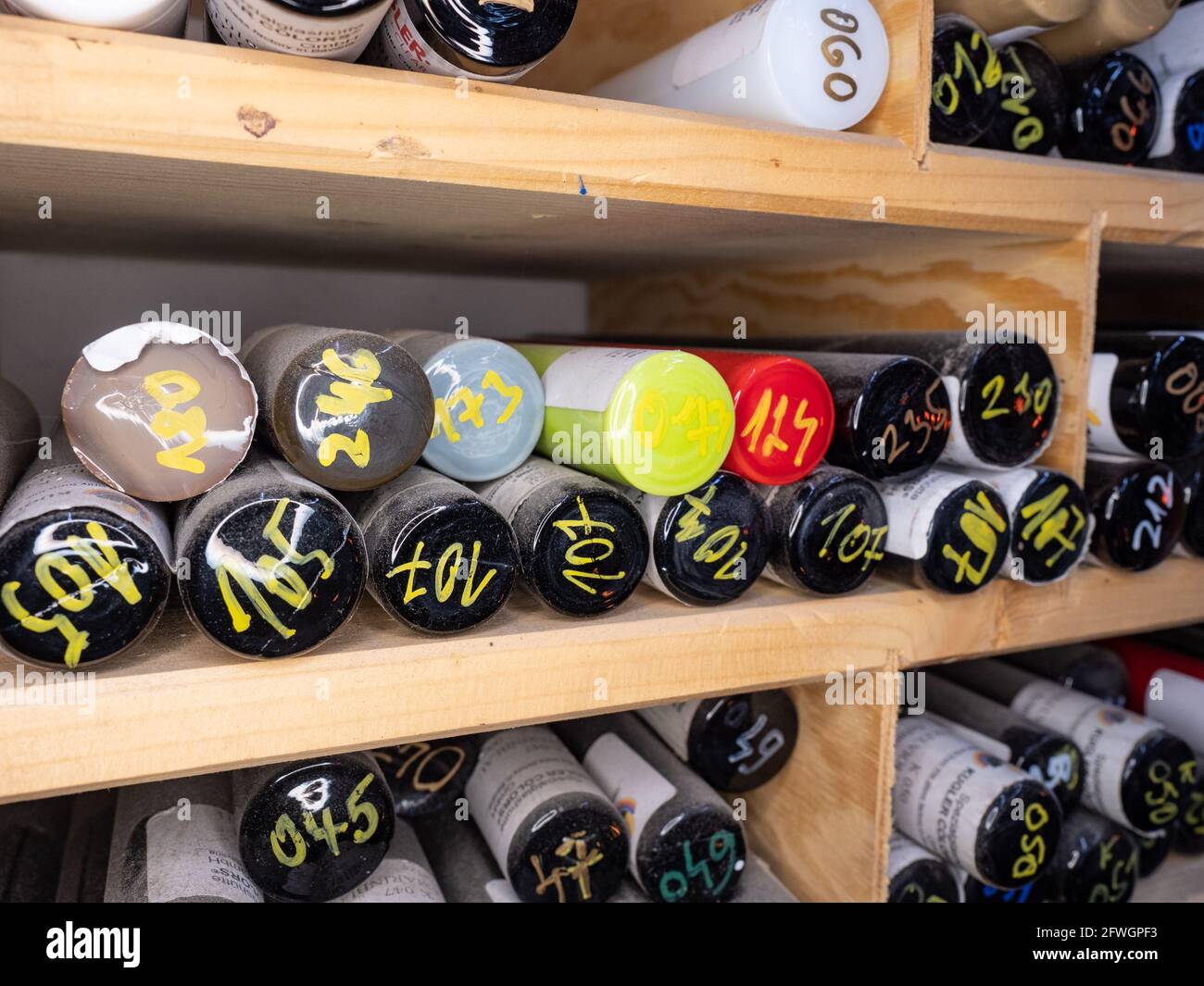 Color glass bars in wooden rack. Bunch of colorful glass rods on shelf ...