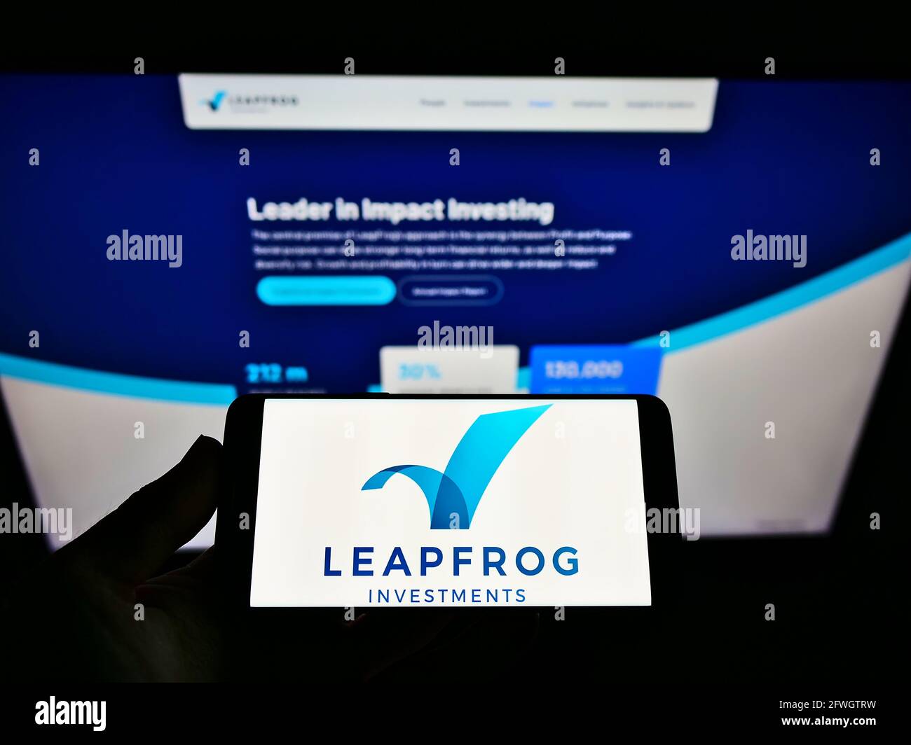 Person holding mobile phone with business logo of private equity firm ...