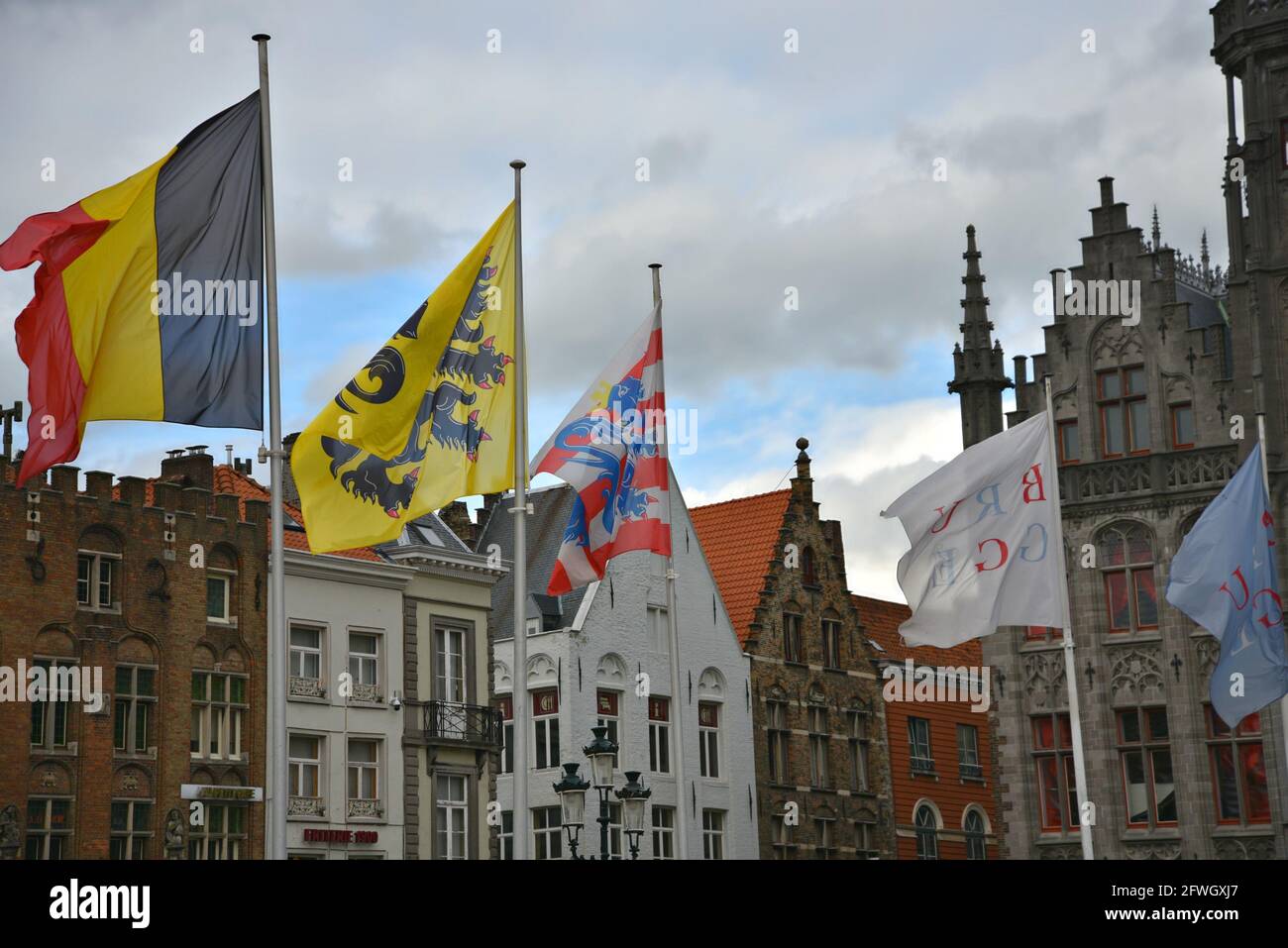 Flemish flags with Gothic Revival buildings in the background at Markt ...