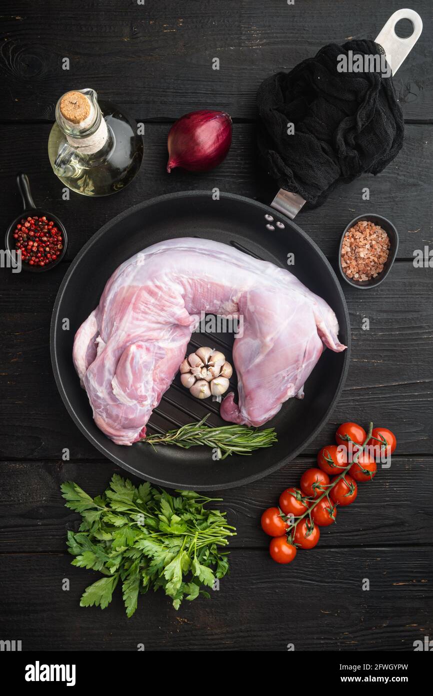 Whole raw rabbit with ingredients set, in cast iron frying pan, on ...