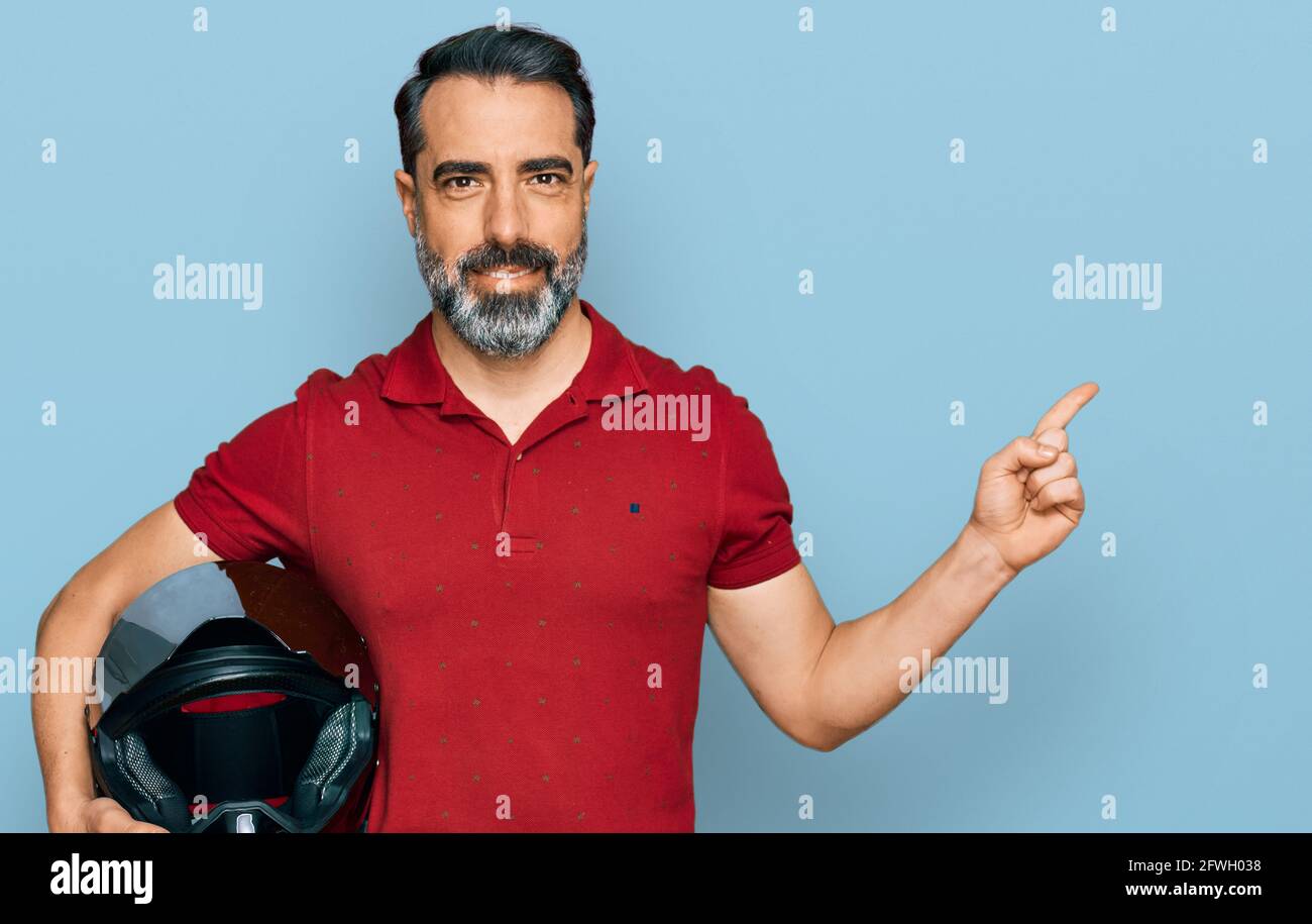 Middle aged man with beard holding motorcycle helmet smiling happy ...