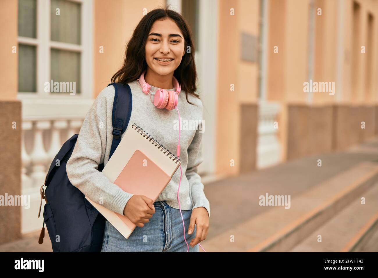 Young middle east student girl smiling happy holding book at the city ...