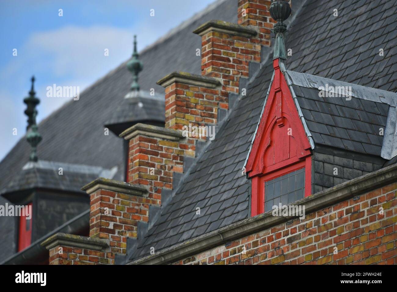 Old Gothic style building shingles rooftop with red attic windows in ...