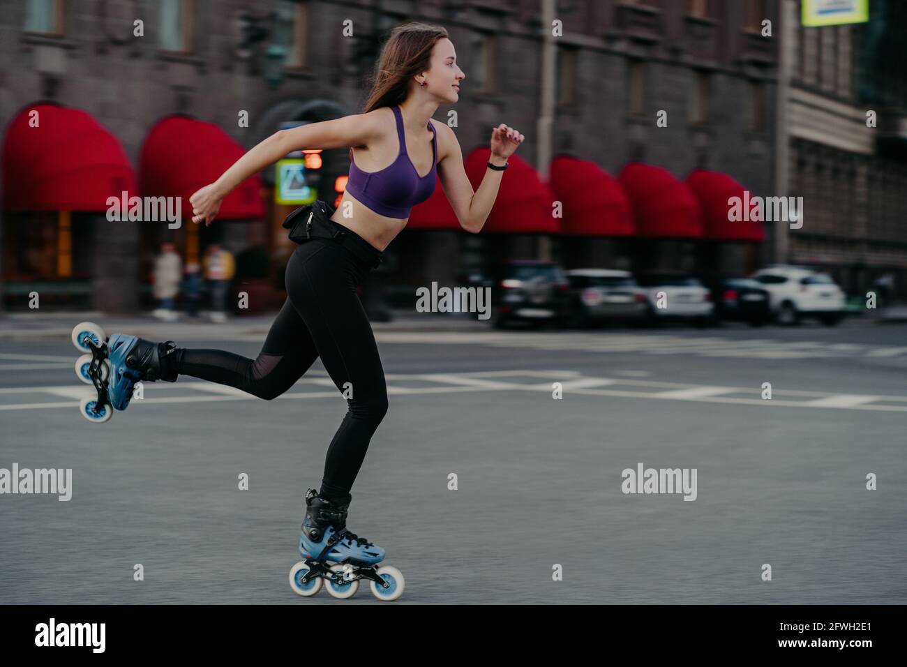 Slim young woman rides fast on rollerskates improves balance agility ...