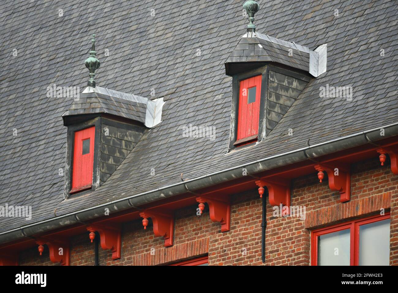 Old Gothic style building shingles rooftop with red attic windows in ...