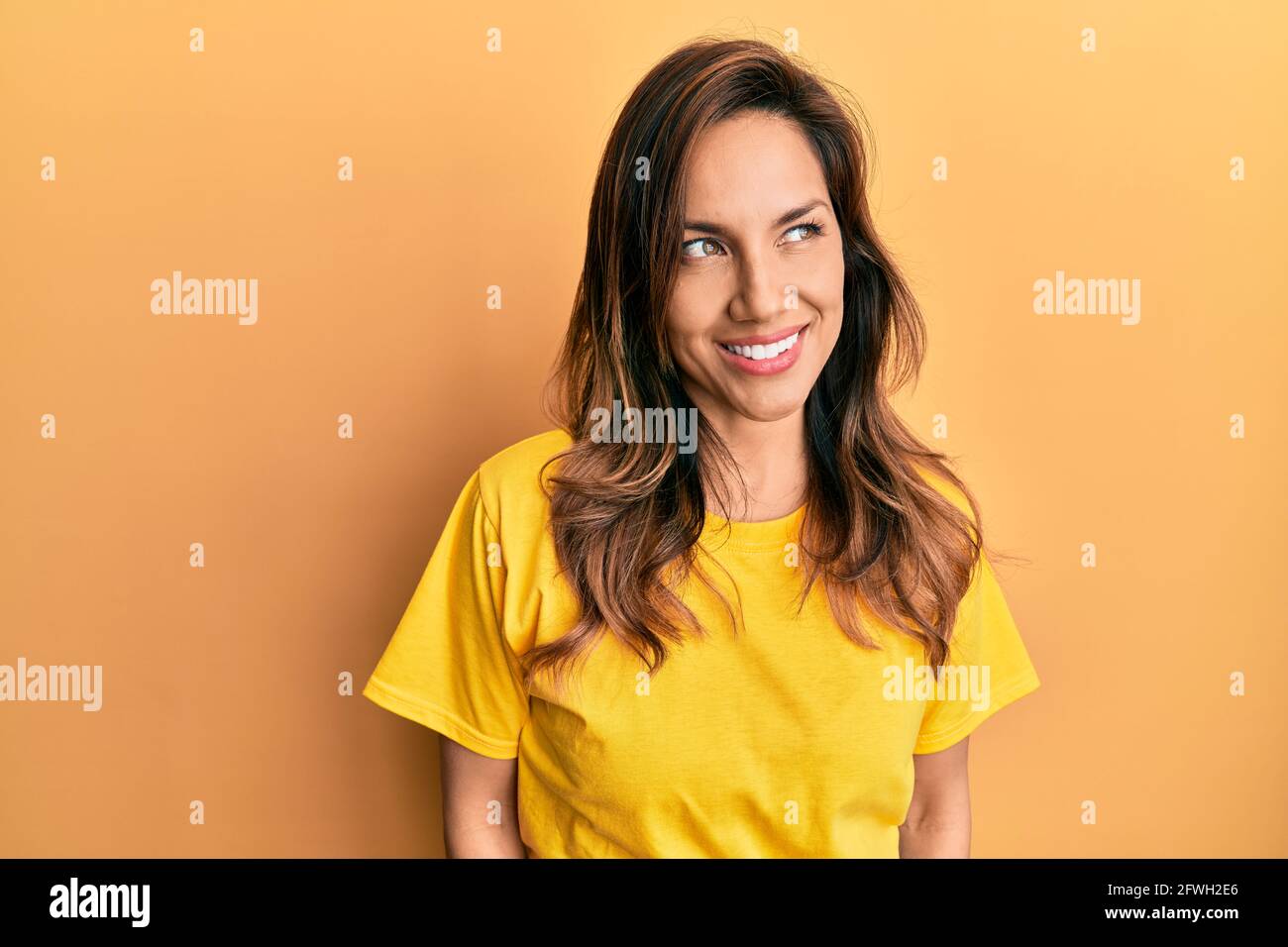 Young latin woman wearing casual clothes looking away to side with ...