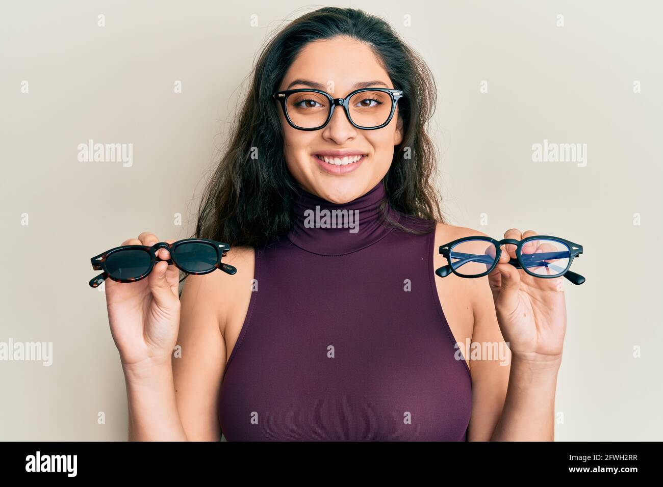 Beautiful middle eastern woman holding different glasses smiling with a ...