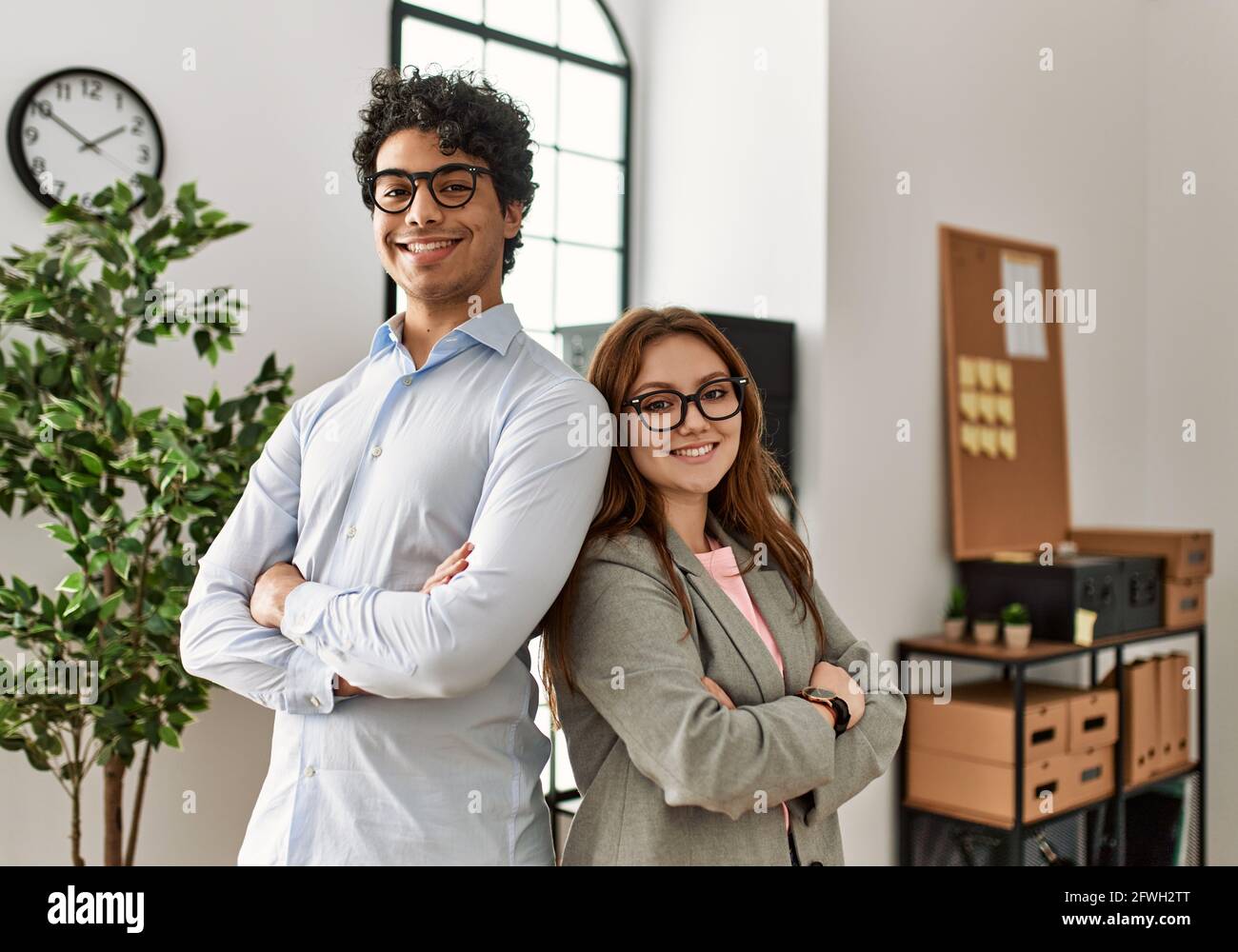 Two business workers smiling happy with arms crossed gesture at the ...