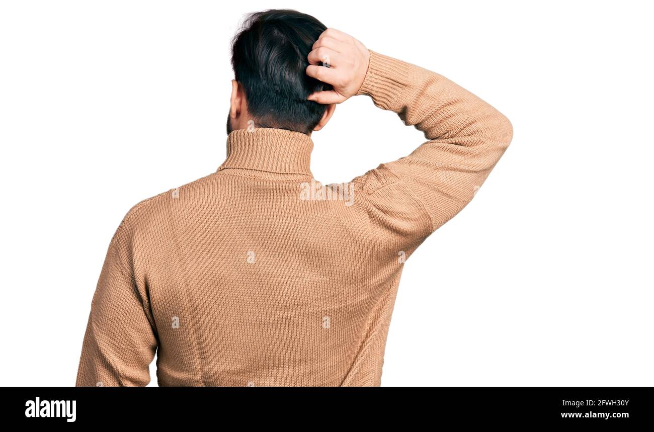Young hispanic man wearing casual clothes backwards thinking about ...