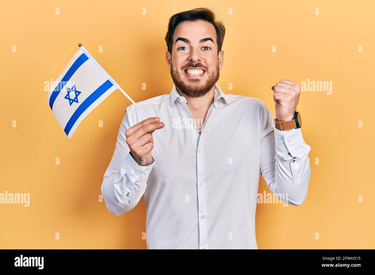 Handsome caucasian man with beard holding israel flag screaming proud ...