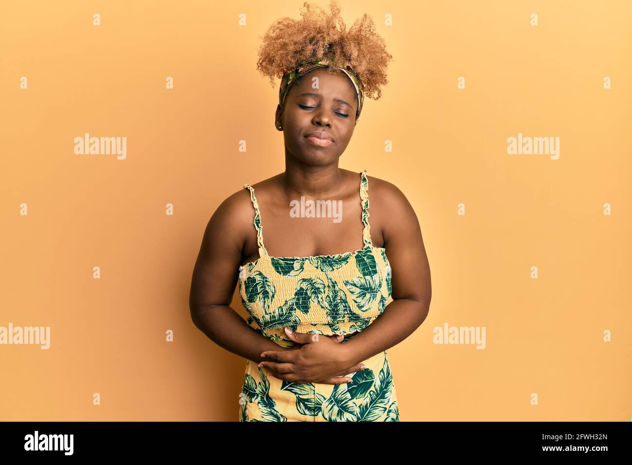 Young african woman with afro hair wearing summer dress with hand on ...