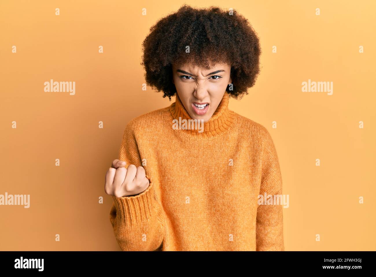 Young hispanic girl wearing wool winter sweater angry and mad raising ...