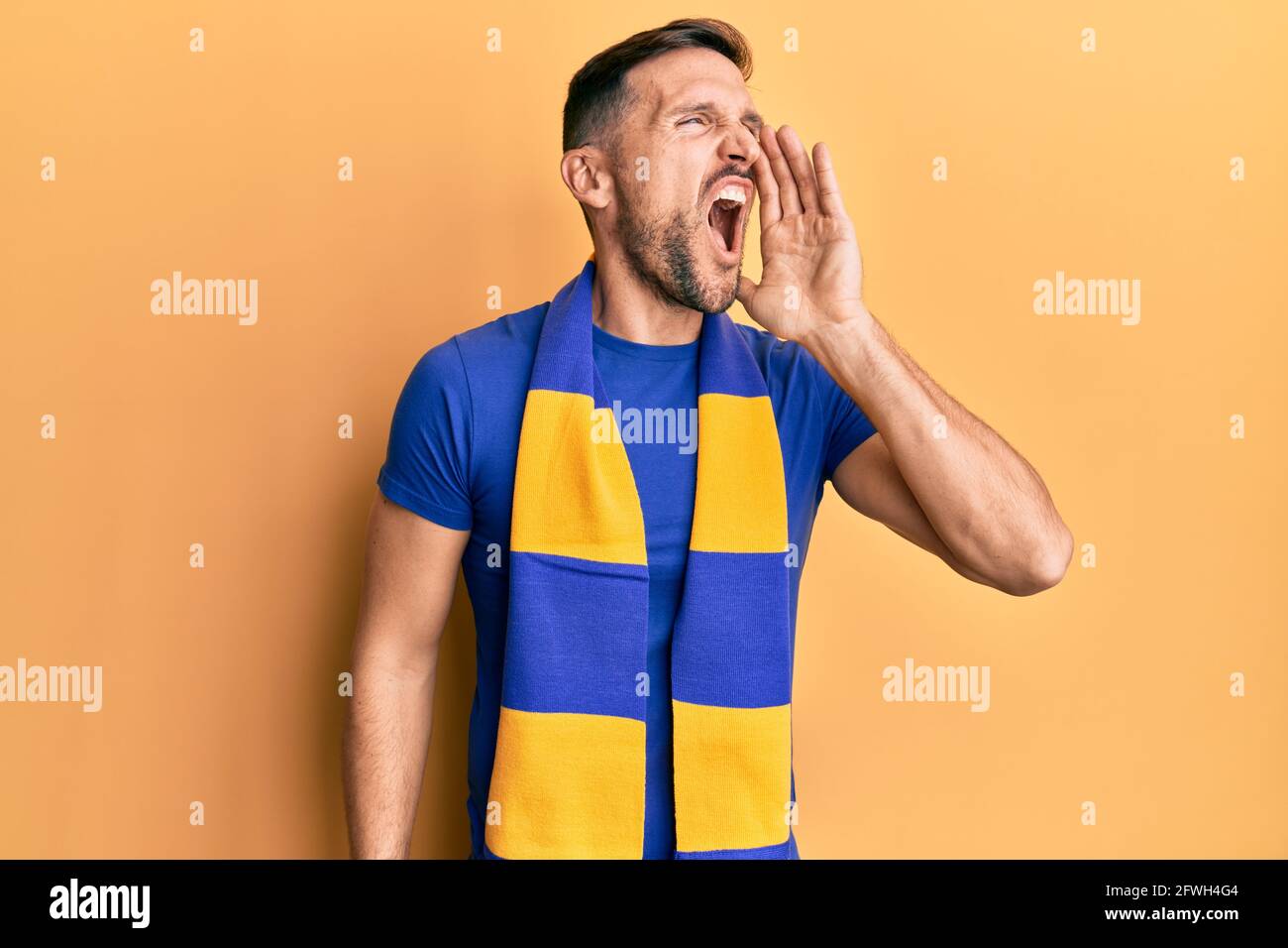 Handsome man with beard football hooligan cheering game shouting and ...