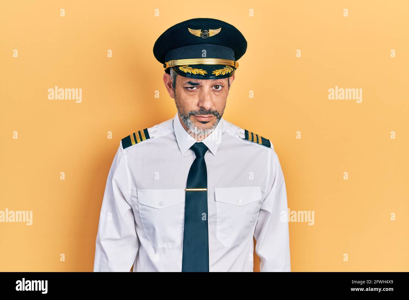 Handsome middle age man with grey hair wearing airplane pilot uniform ...