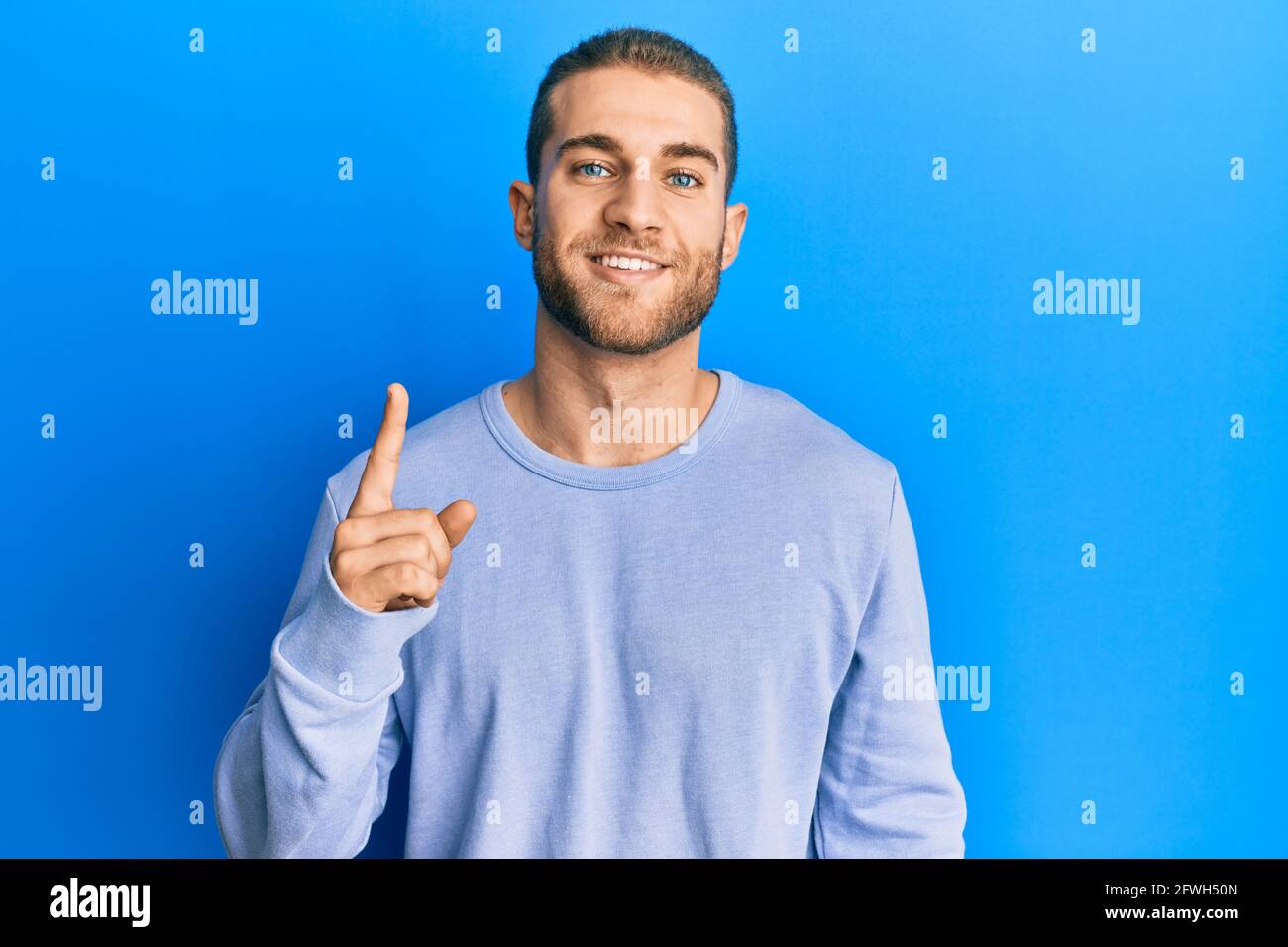 Young caucasian man wearing casual clothes smiling with an idea or ...