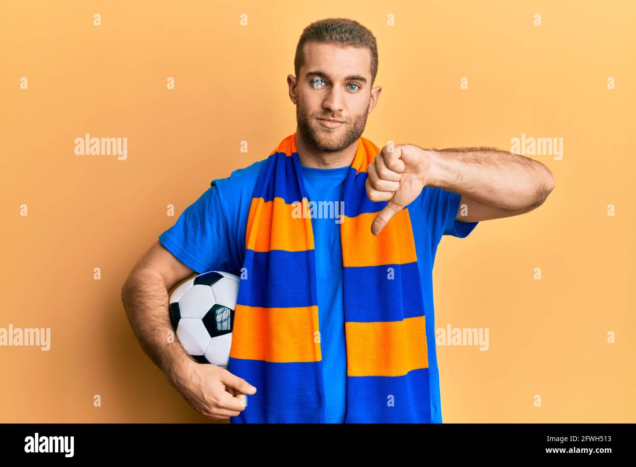 Young caucasian man football hooligan cheering game holding ball with ...