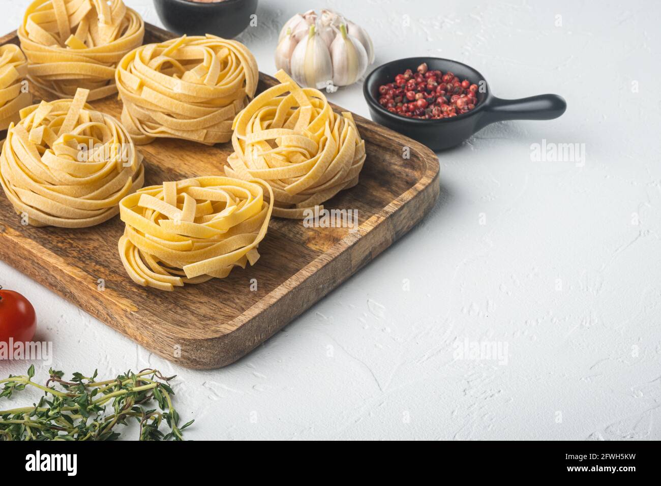 Rolled tagliatelle shape of italian pasta with ingredients set, on ...