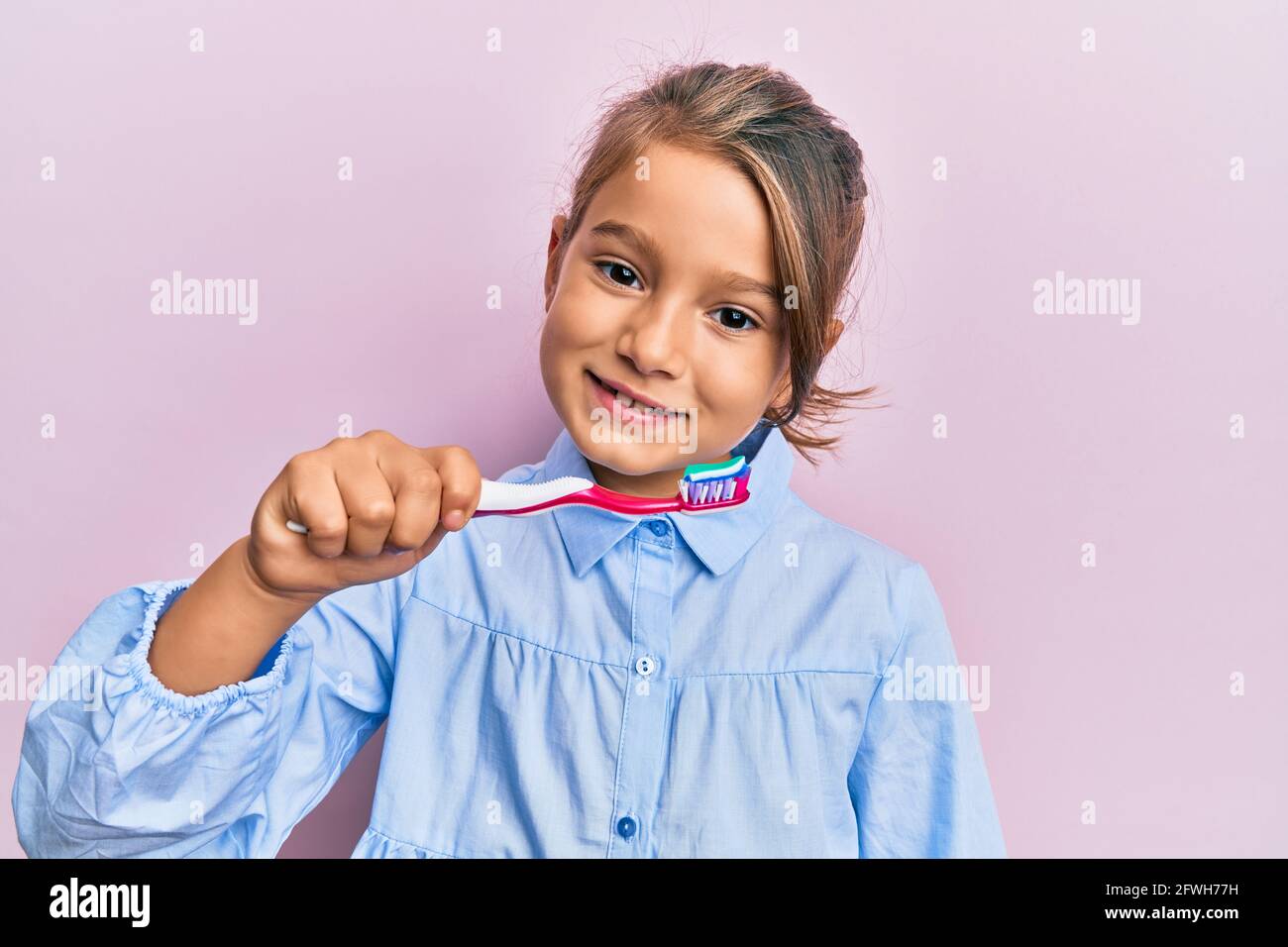 Little beautiful girl holding toothbrush with toothpaste looking ...