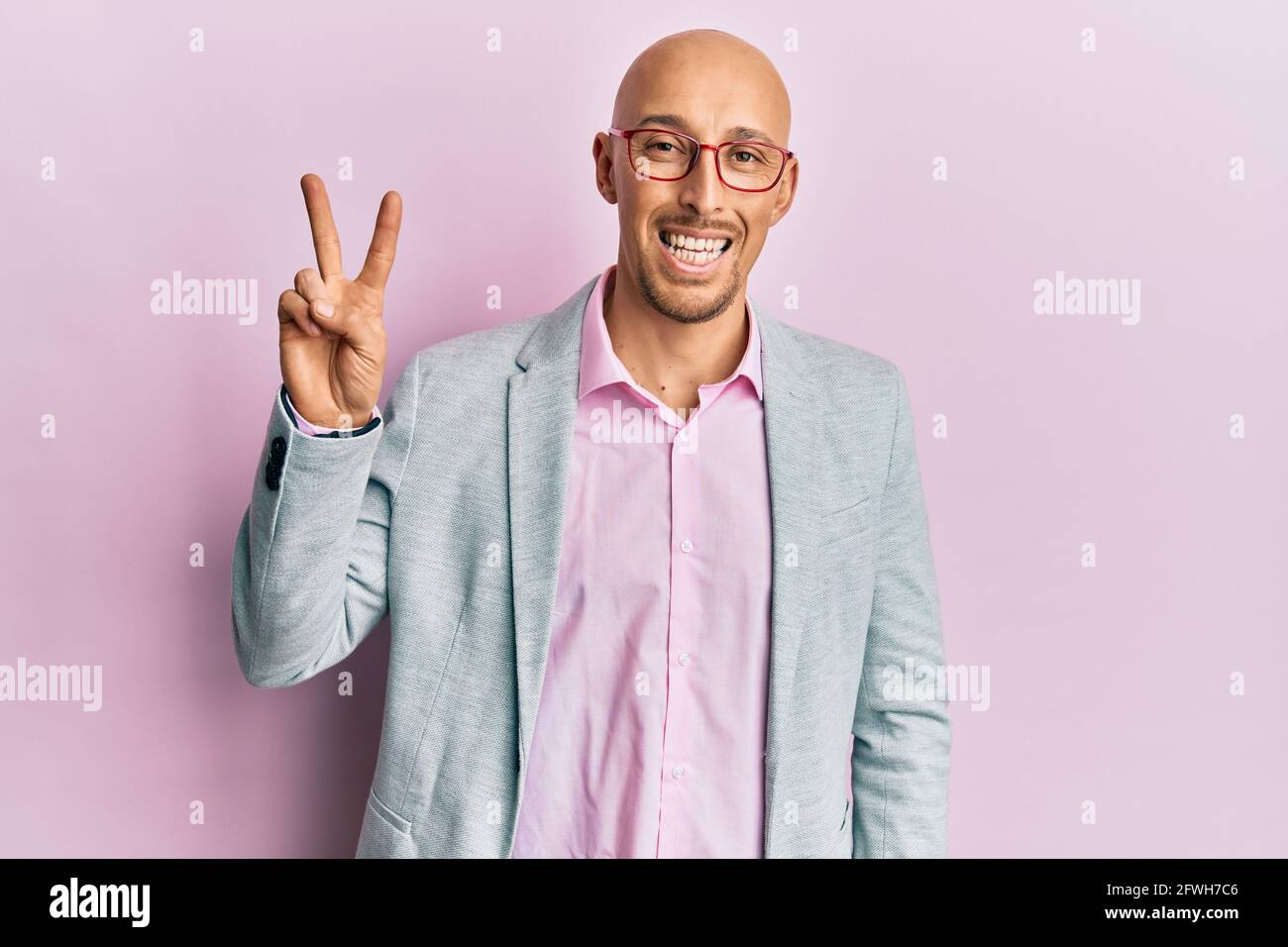 Bald man with beard wearing business clothes and glasses smiling with ...
