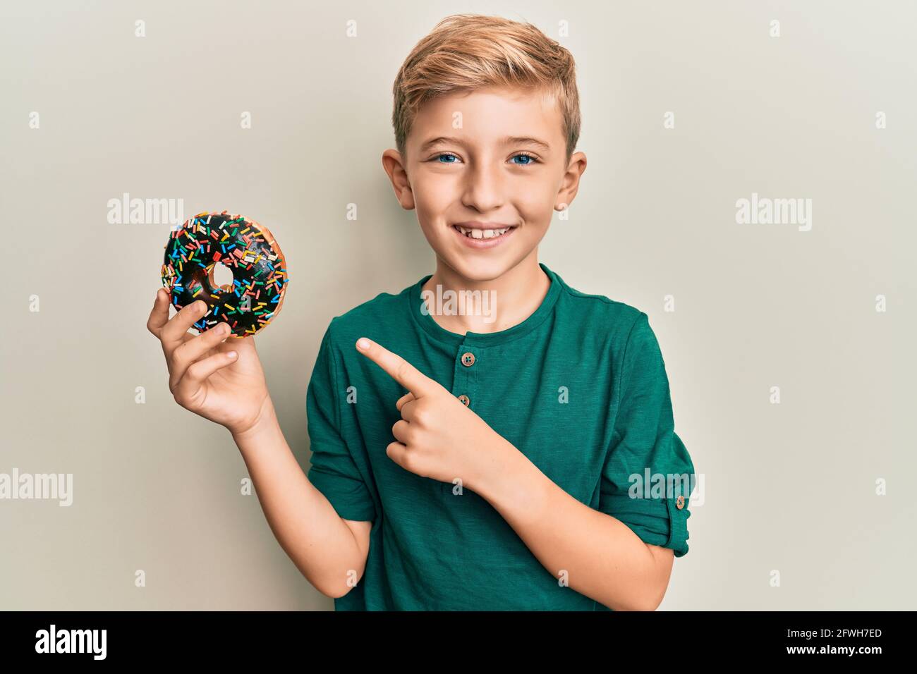 Little caucasian boy kid holding chocolate doughnut smiling happy ...
