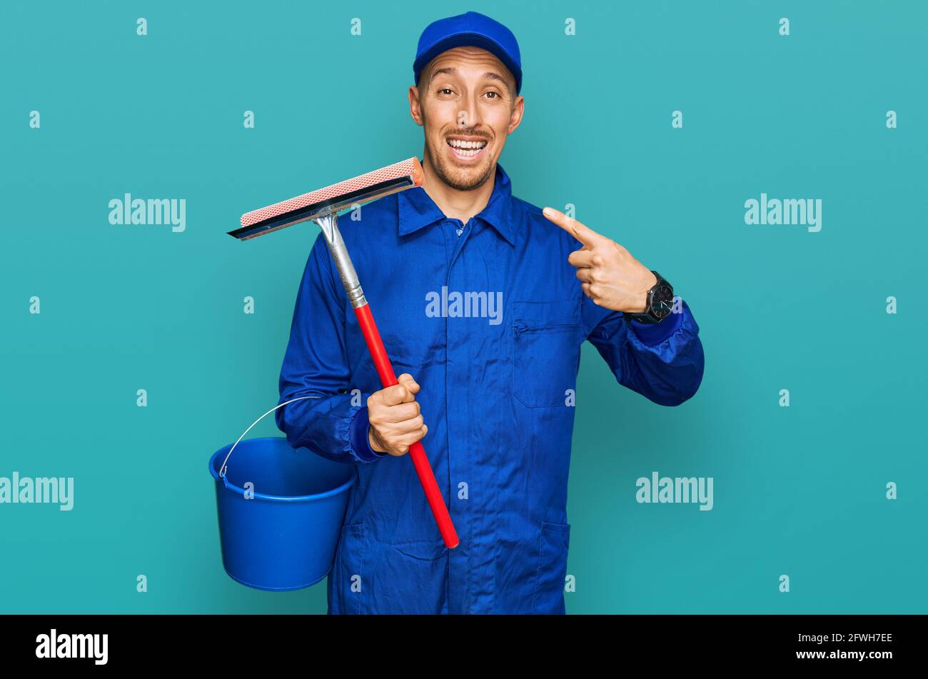 Bald man with beard wearing glass cleaner uniform and squeegee smiling ...