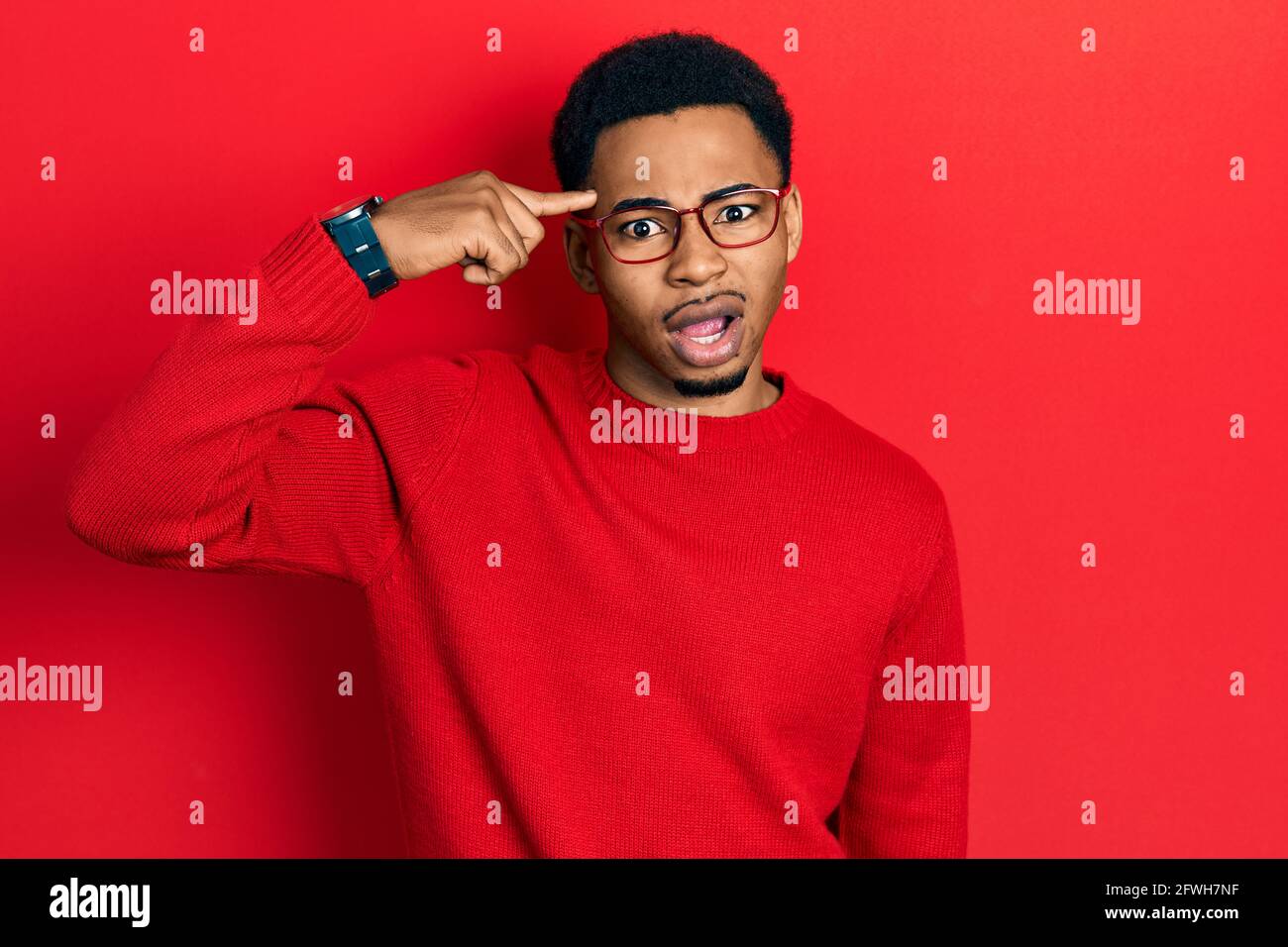 Young african american man pointing head with finger in shock face ...