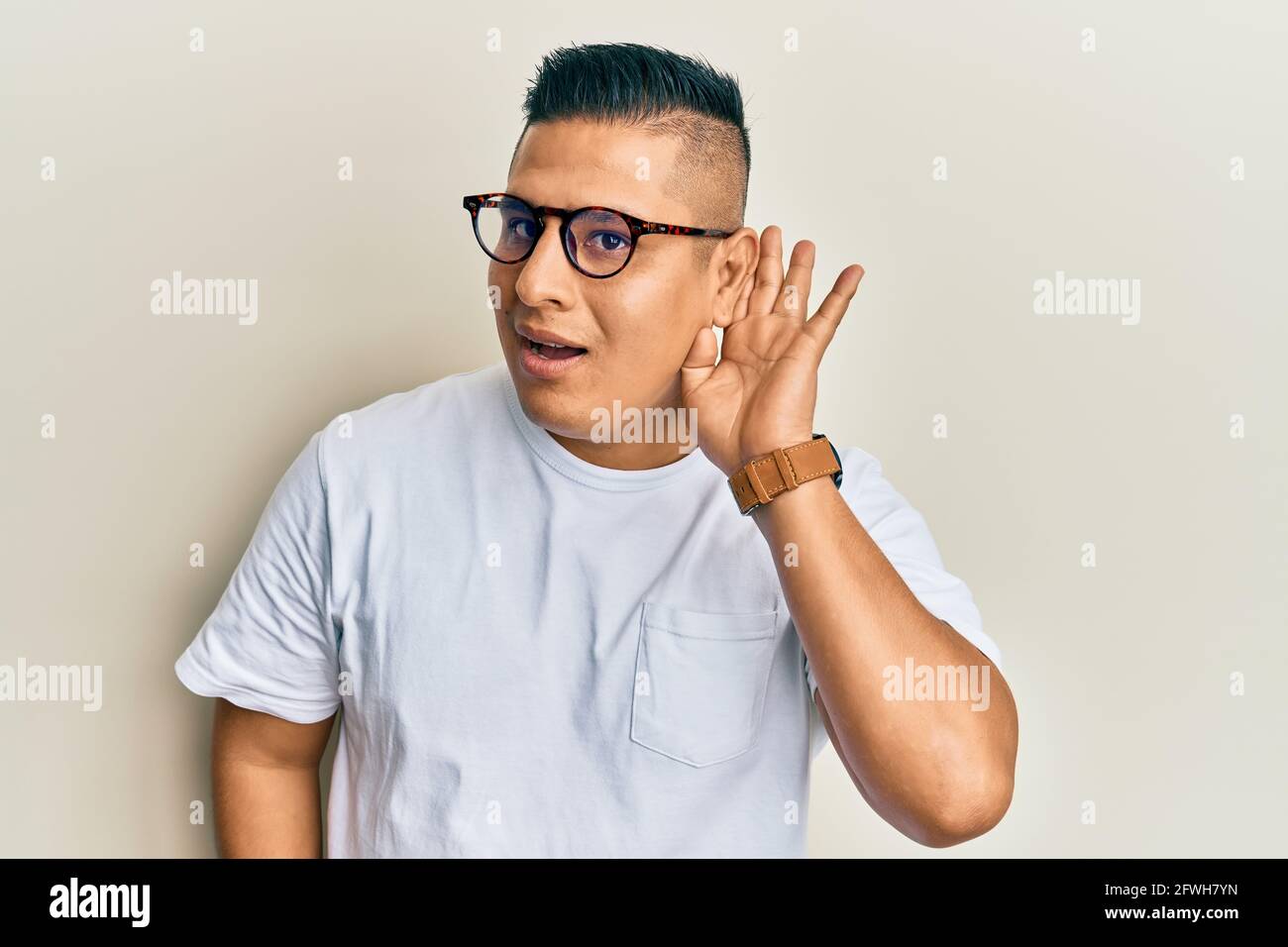 Young latin man wearing casual clothes and glasses smiling with hand ...