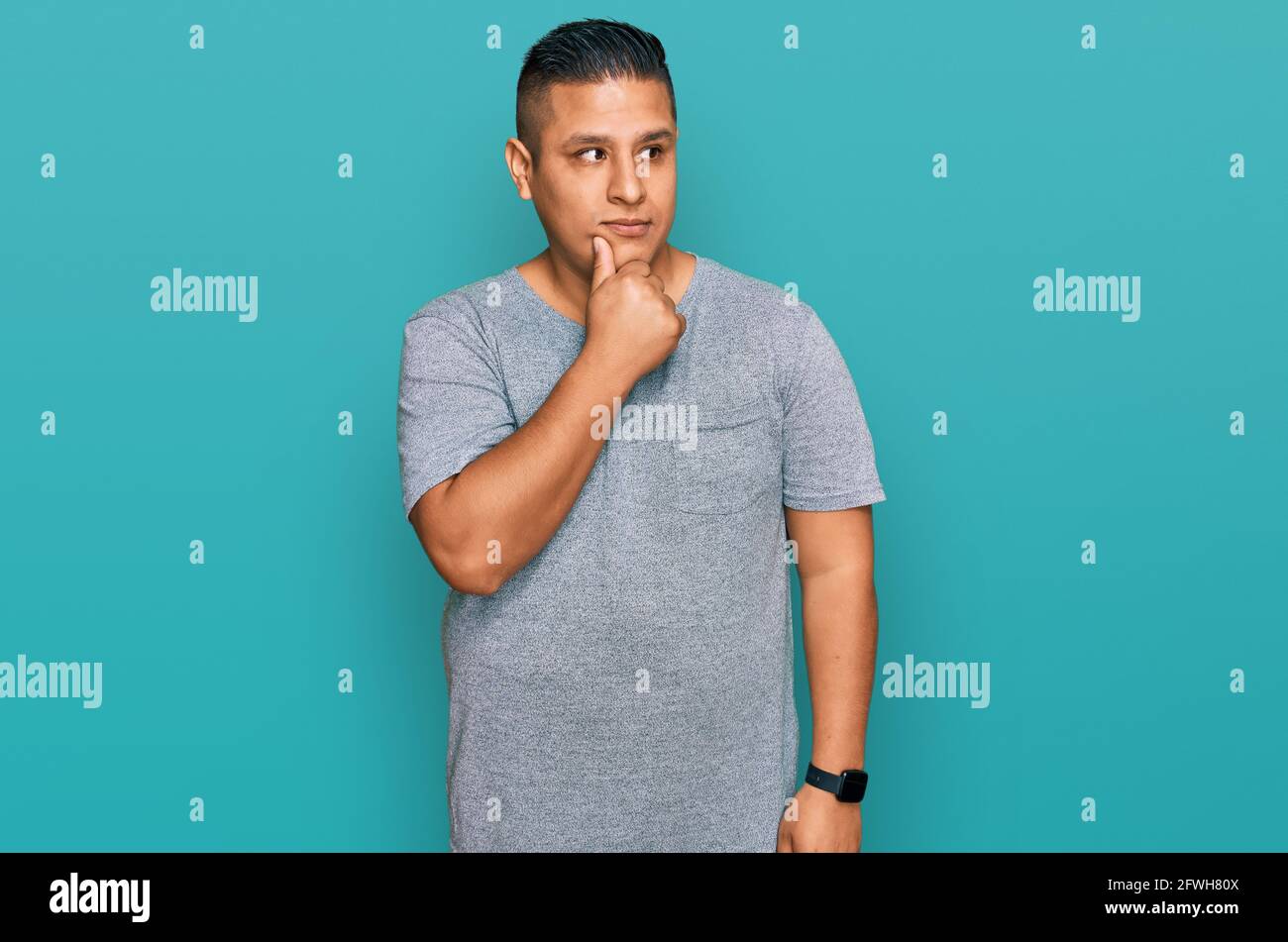 Young latin man wearing casual clothes with hand on chin thinking about ...