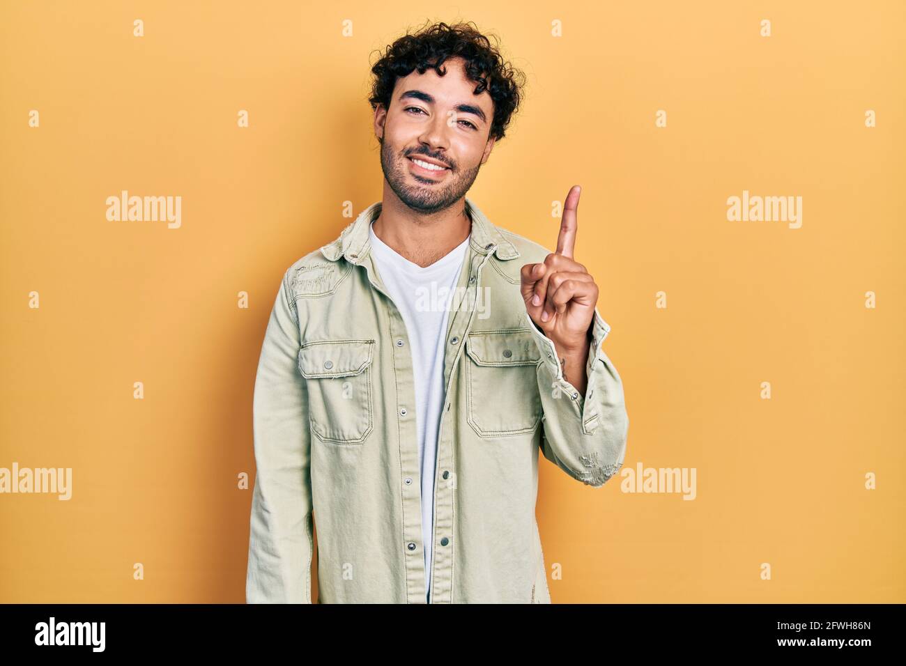 Young hispanic man wearing casual clothes showing and pointing up with ...