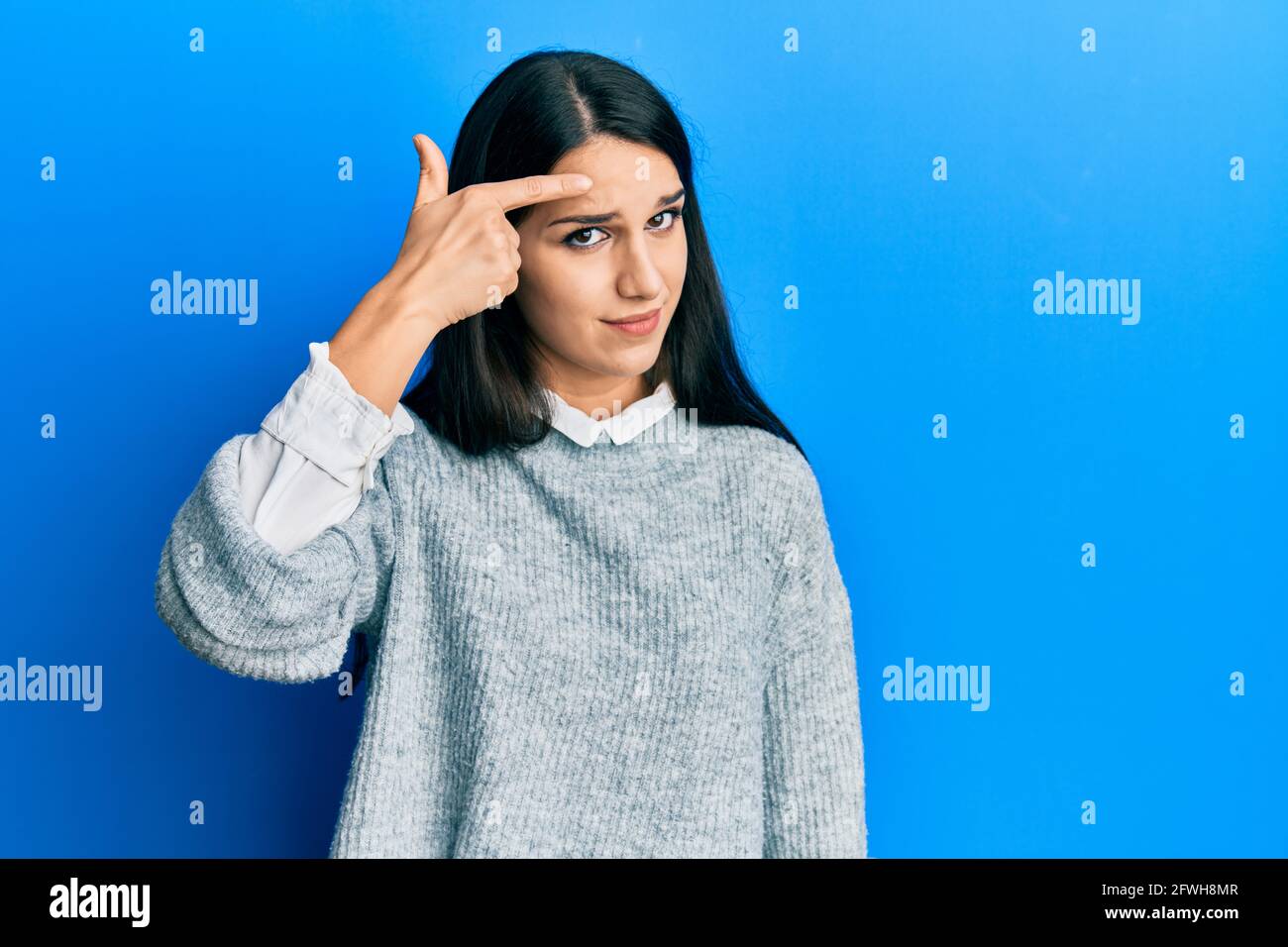 Young hispanic woman wearing casual clothes pointing unhappy to pimple ...