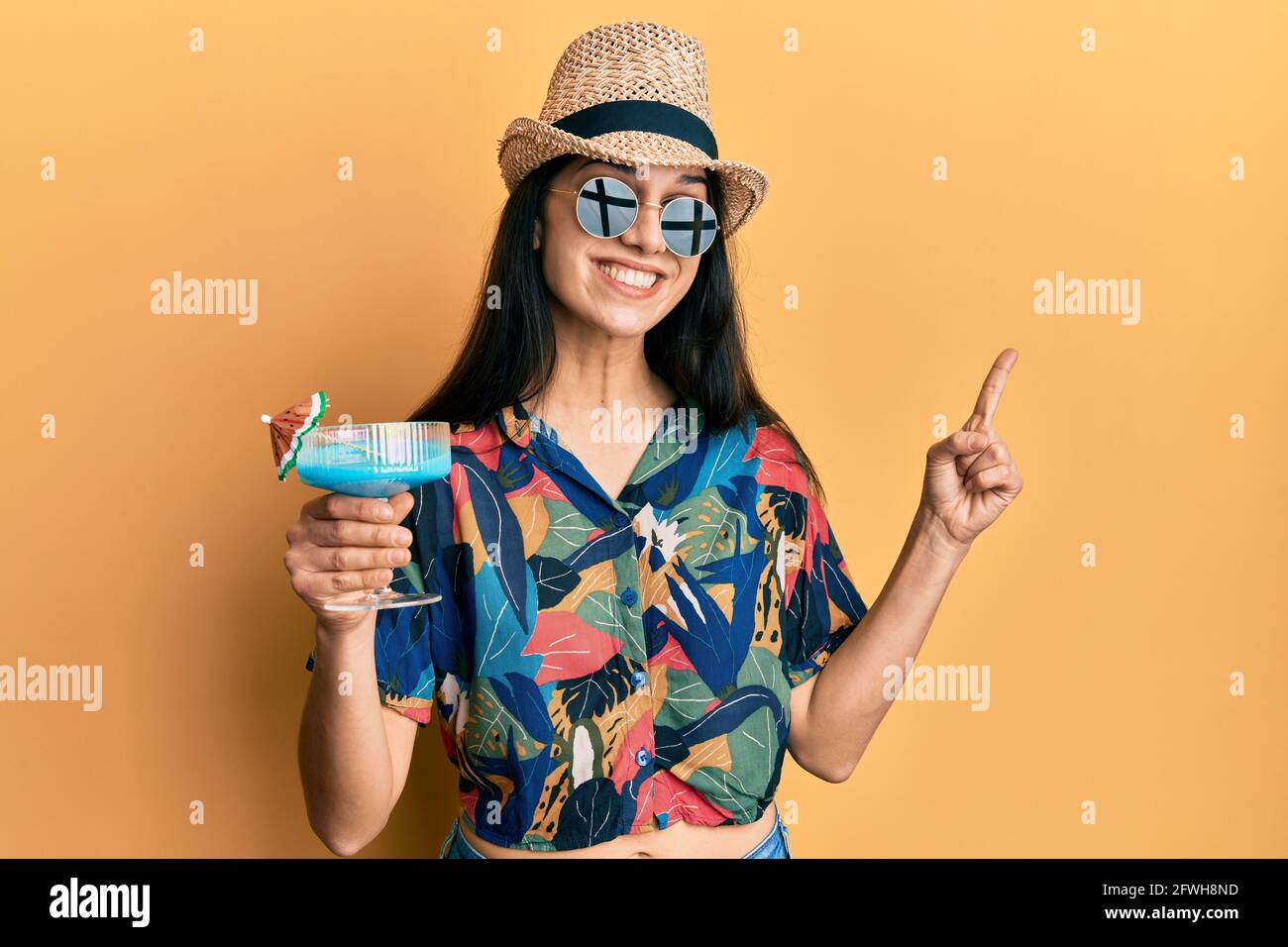 Young hispanic woman wearing summer style drinking tropical cocktail ...