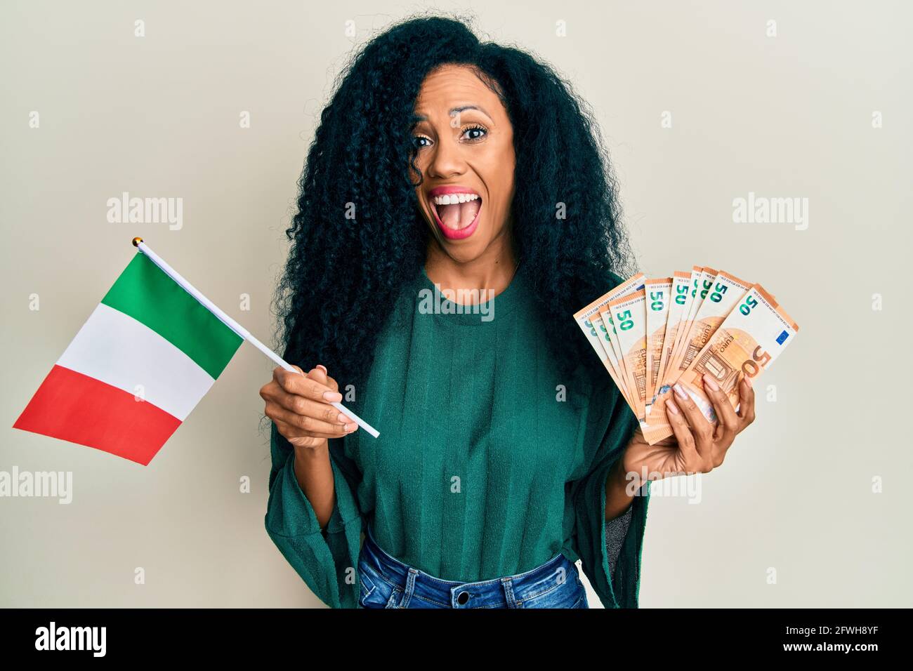 Middle age african american woman holding italy flag and euros ...