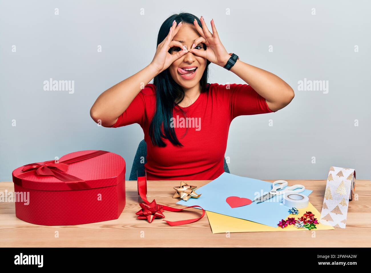 Beautiful hispanic woman with nose piercing doing handcraft creative ...