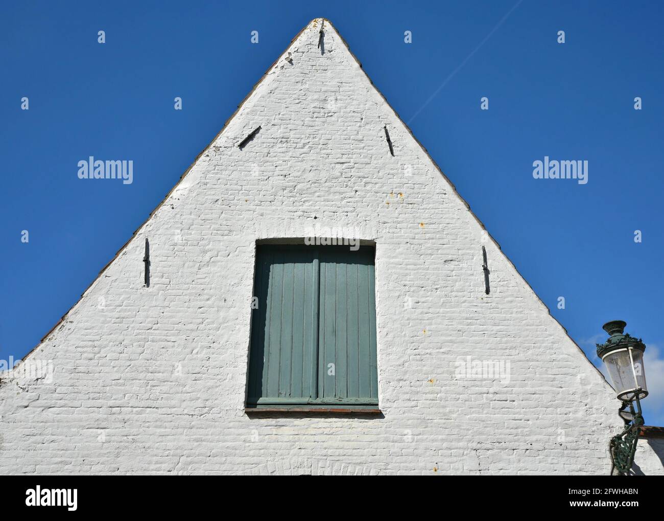 Gothic Revival style house white brick facade with a pointed rooftop in ...
