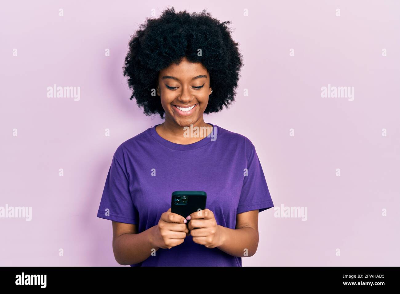Young african american woman using smartphone typing message smiling ...