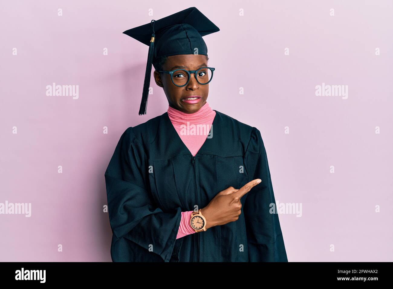 Young african american girl wearing graduation cap and ceremony robe ...