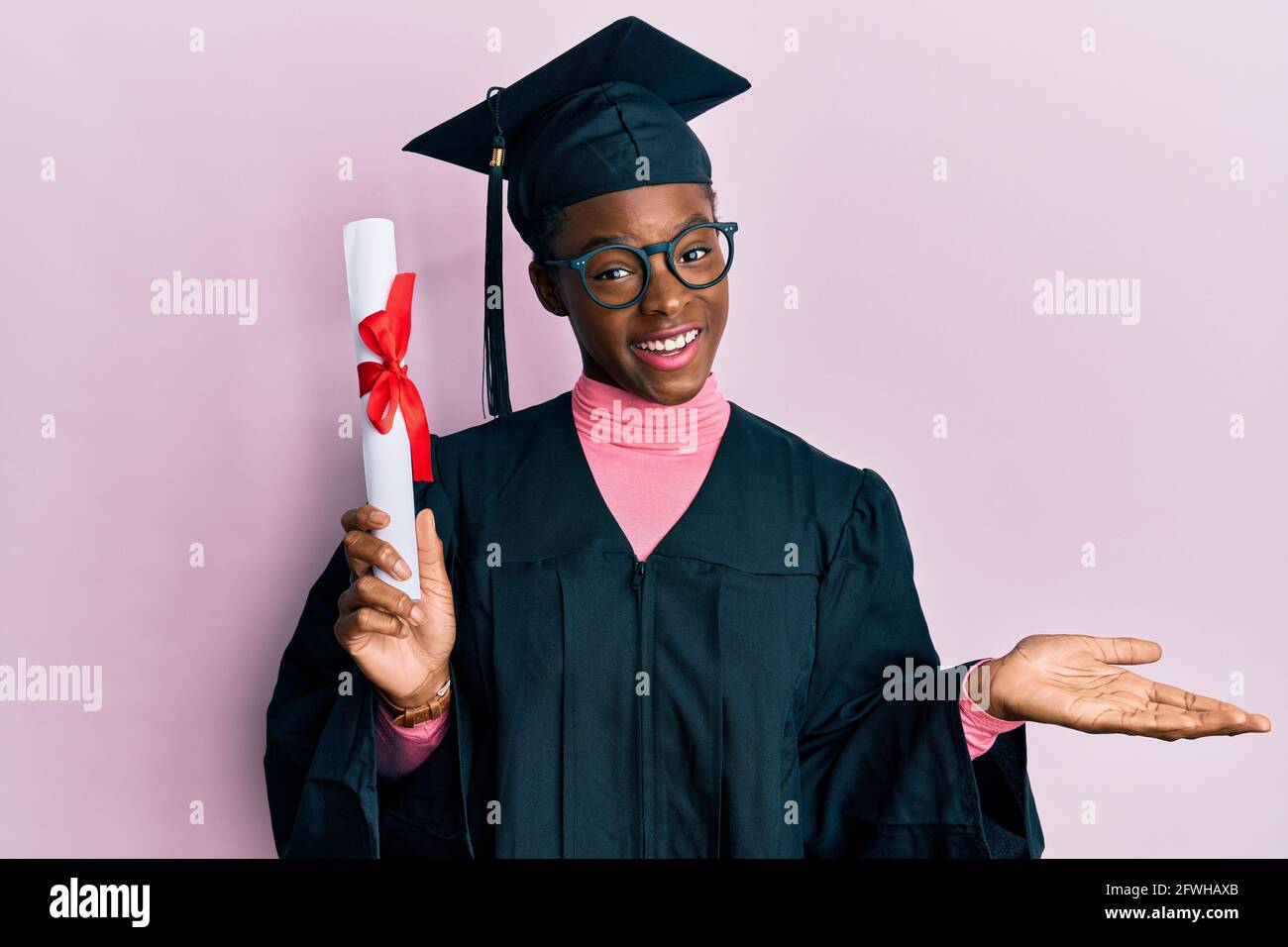 Young african american girl wearing graduation cap and ceremony robe ...