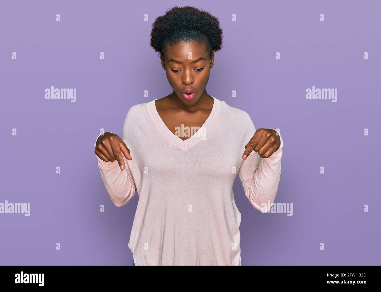 Young african american girl wearing casual clothes pointing down with ...