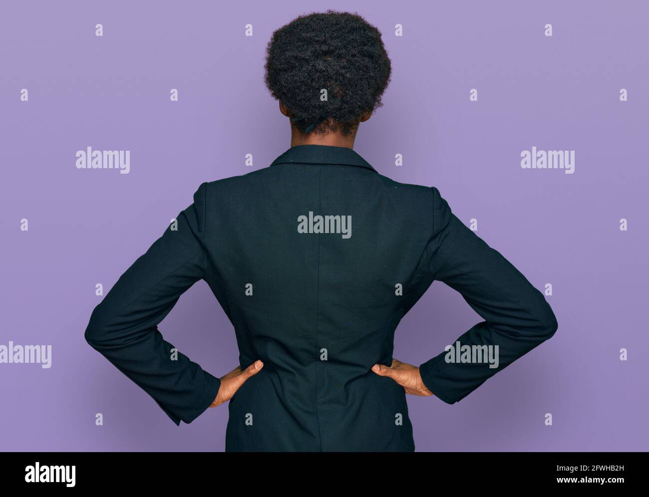 Young african american girl wearing business clothes standing backwards ...