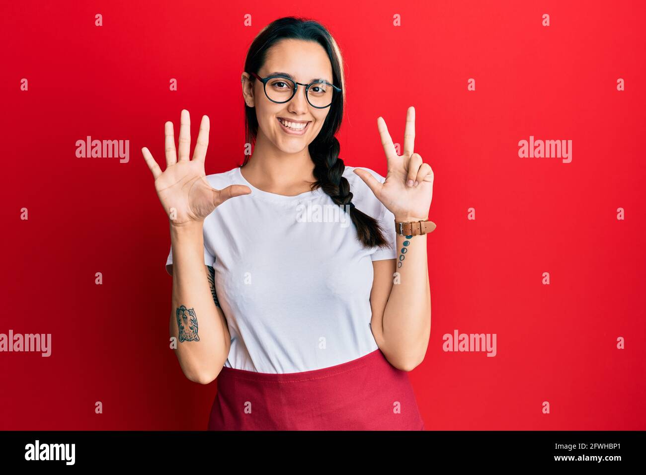 Young hispanic woman wearing professional waitress apron showing and ...